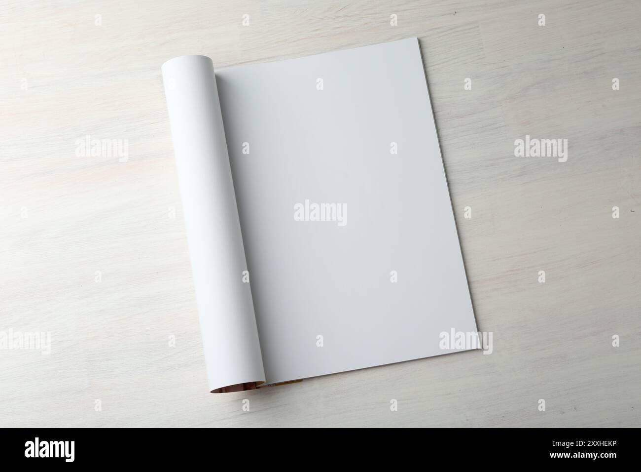 Open magazine with blank page on light wooden table, top view. Mockup ...