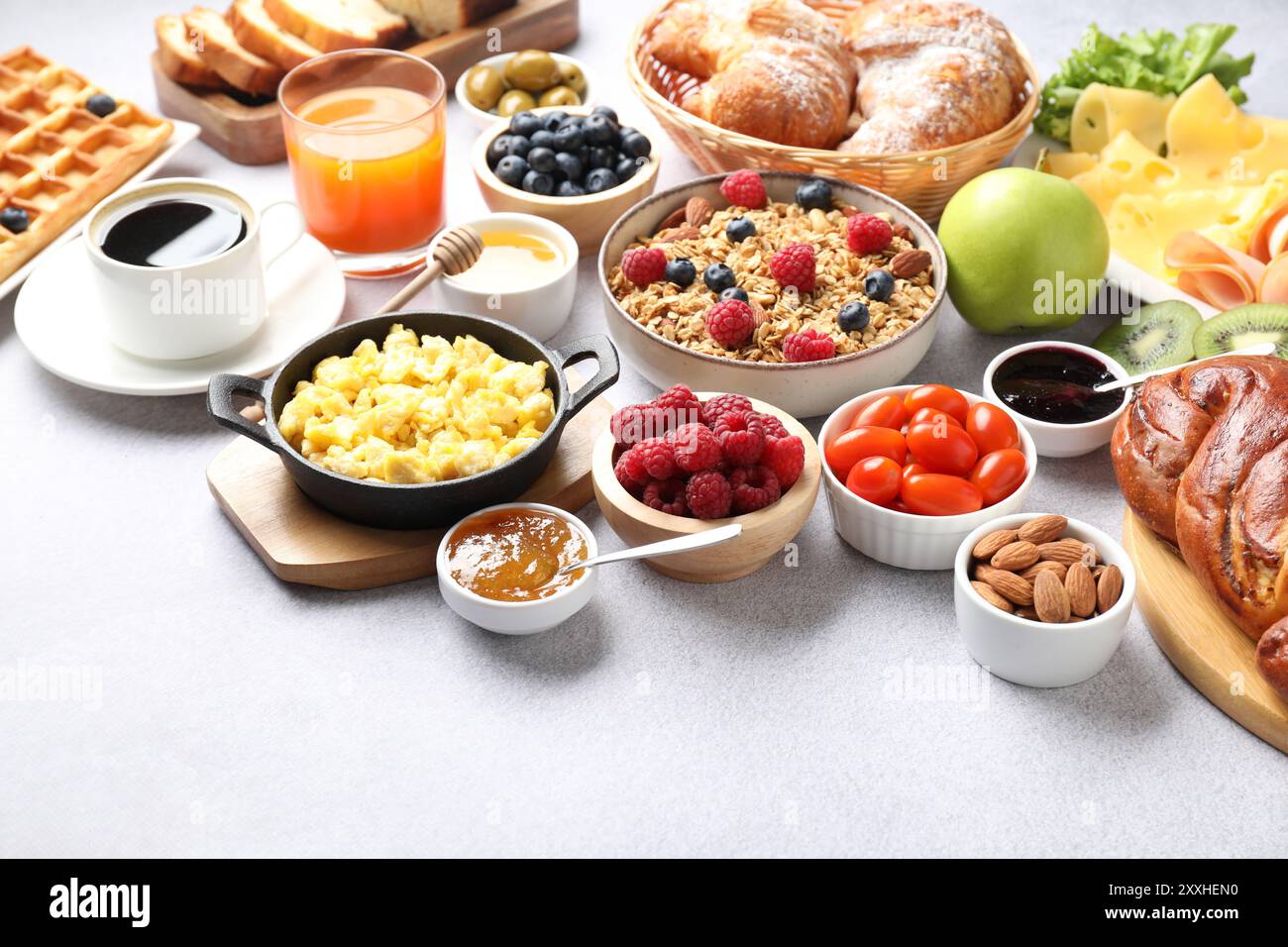 Tasty breakfast. Many different food and drinks on grey textured table ...