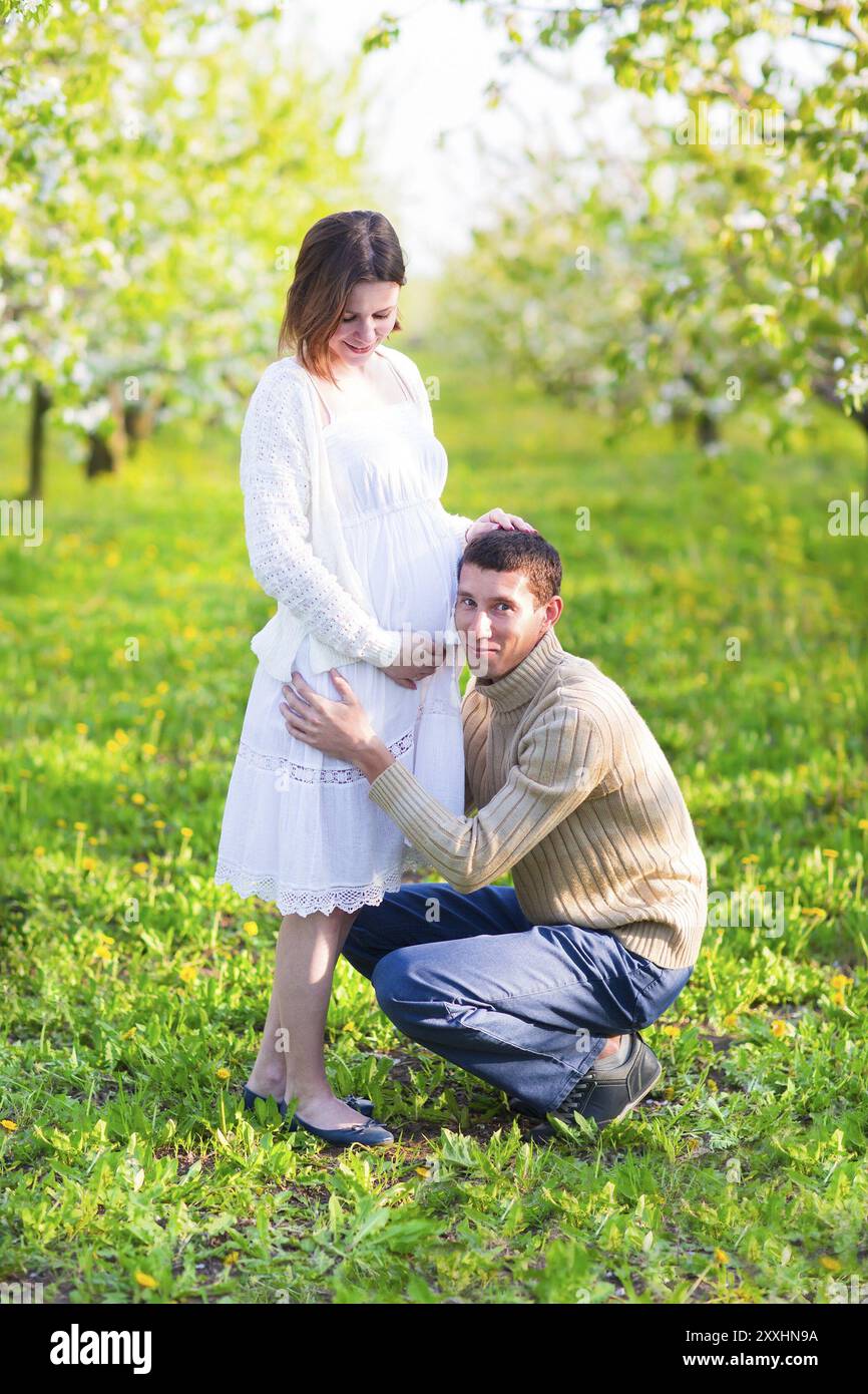 Portrait of a happy pregnant couple in the blossom garden Stock Photo ...