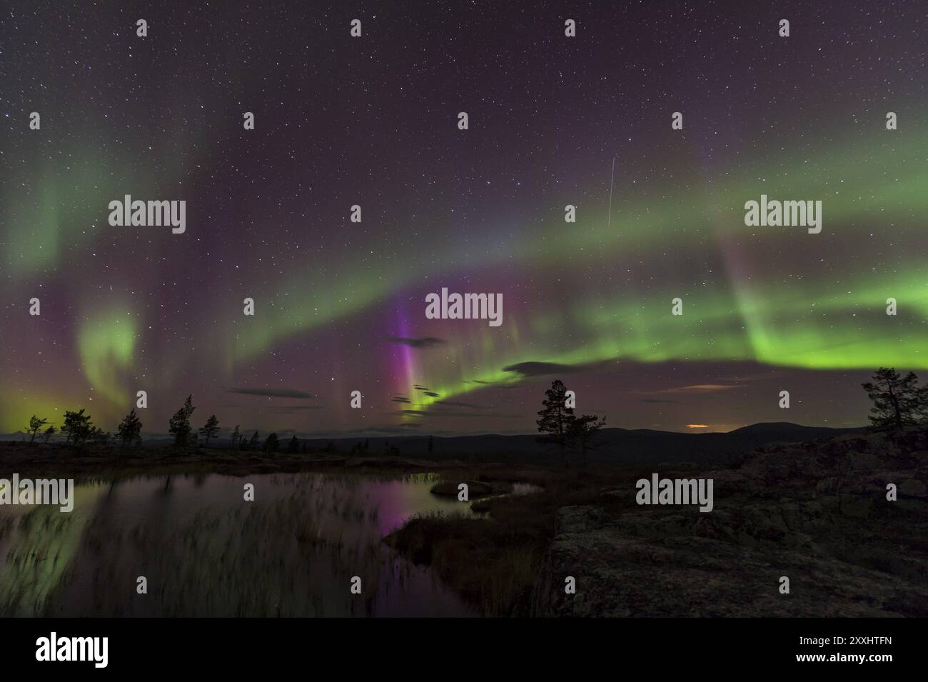 Northern Lights (Aurora borealis) reflected in a mountain lake ...