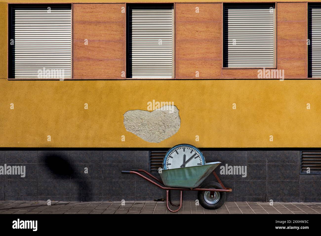 Transporting a railway station clock in a wheelbarrow, symbolic image ...