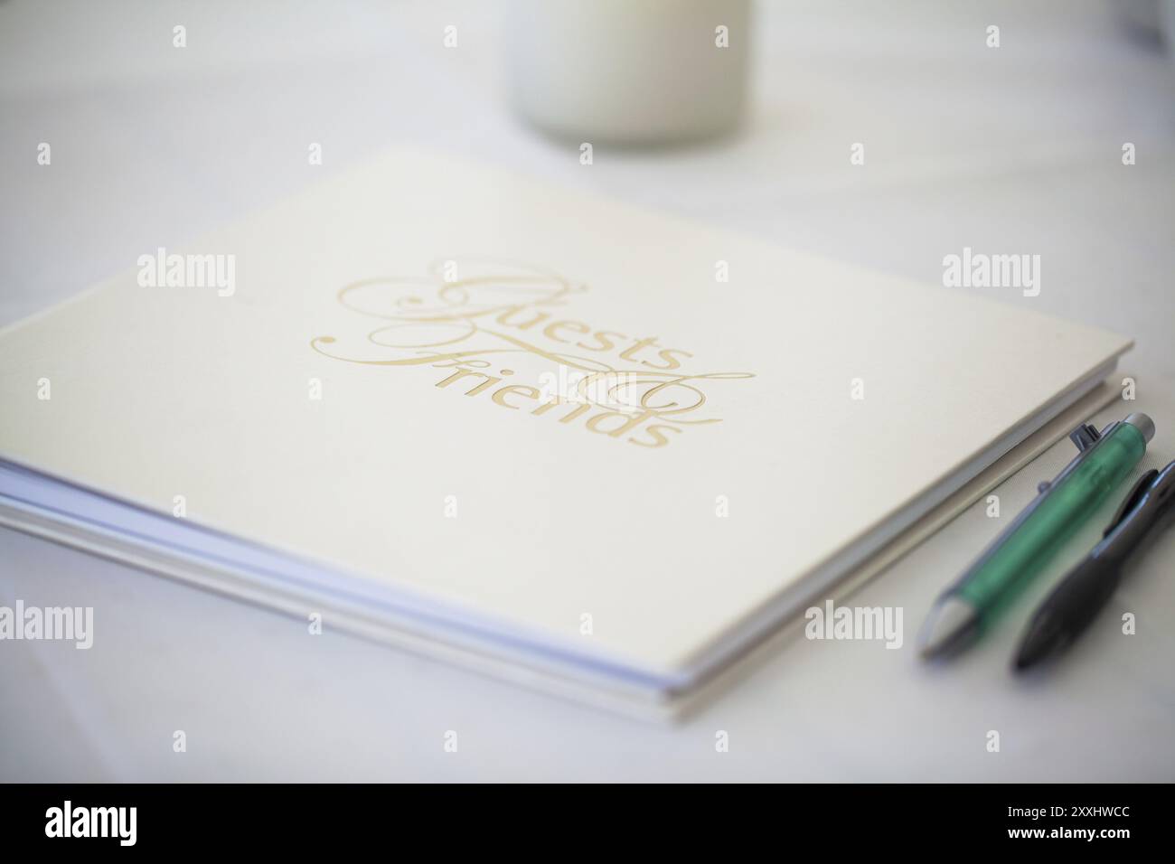 White guest book with engraved letters and two pens Stock Photo - Alamy