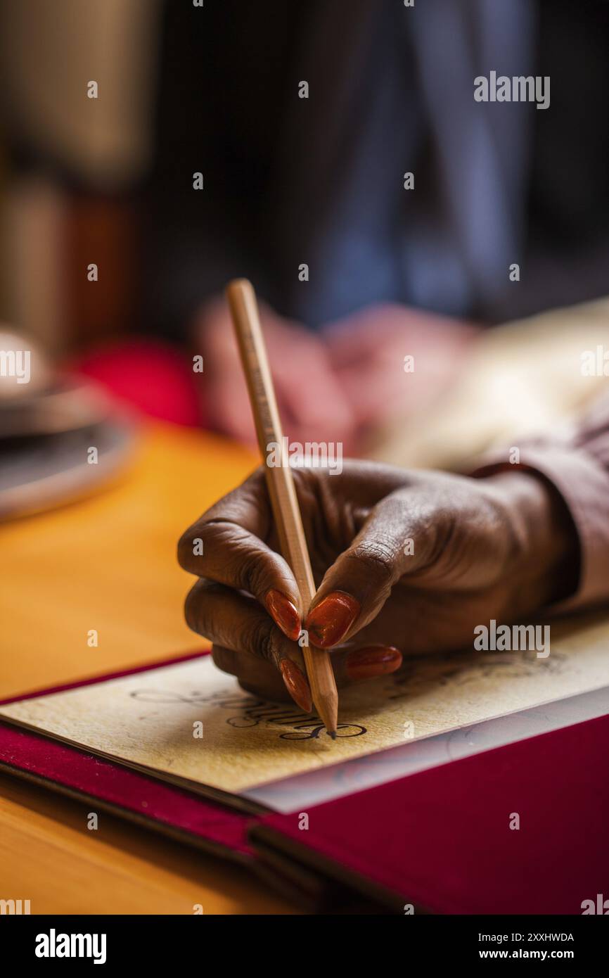 A woman's hand writes with a pencil Stock Photo - Alamy