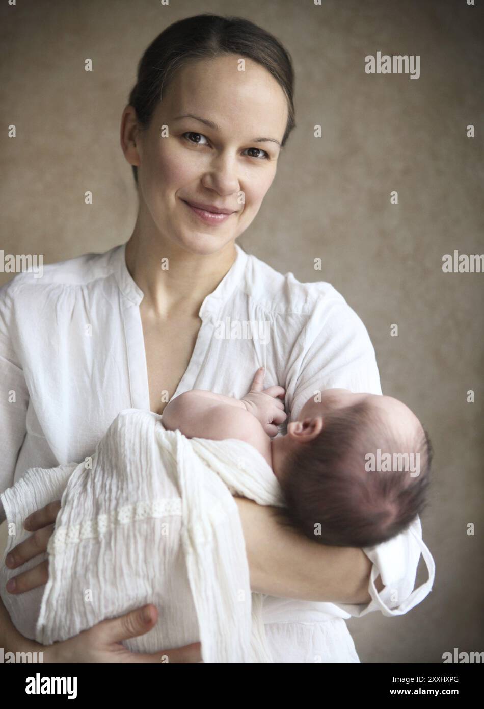 One month old baby boy falling asleep in the arms of her mother Stock ...