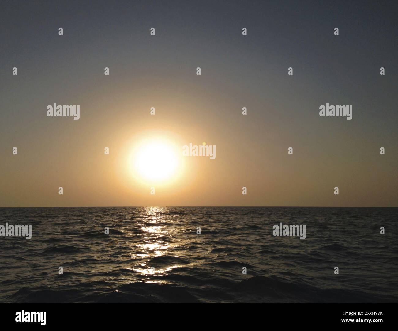 Beautiful sunset sky over the navy blue ocean Stock Photo - Alamy