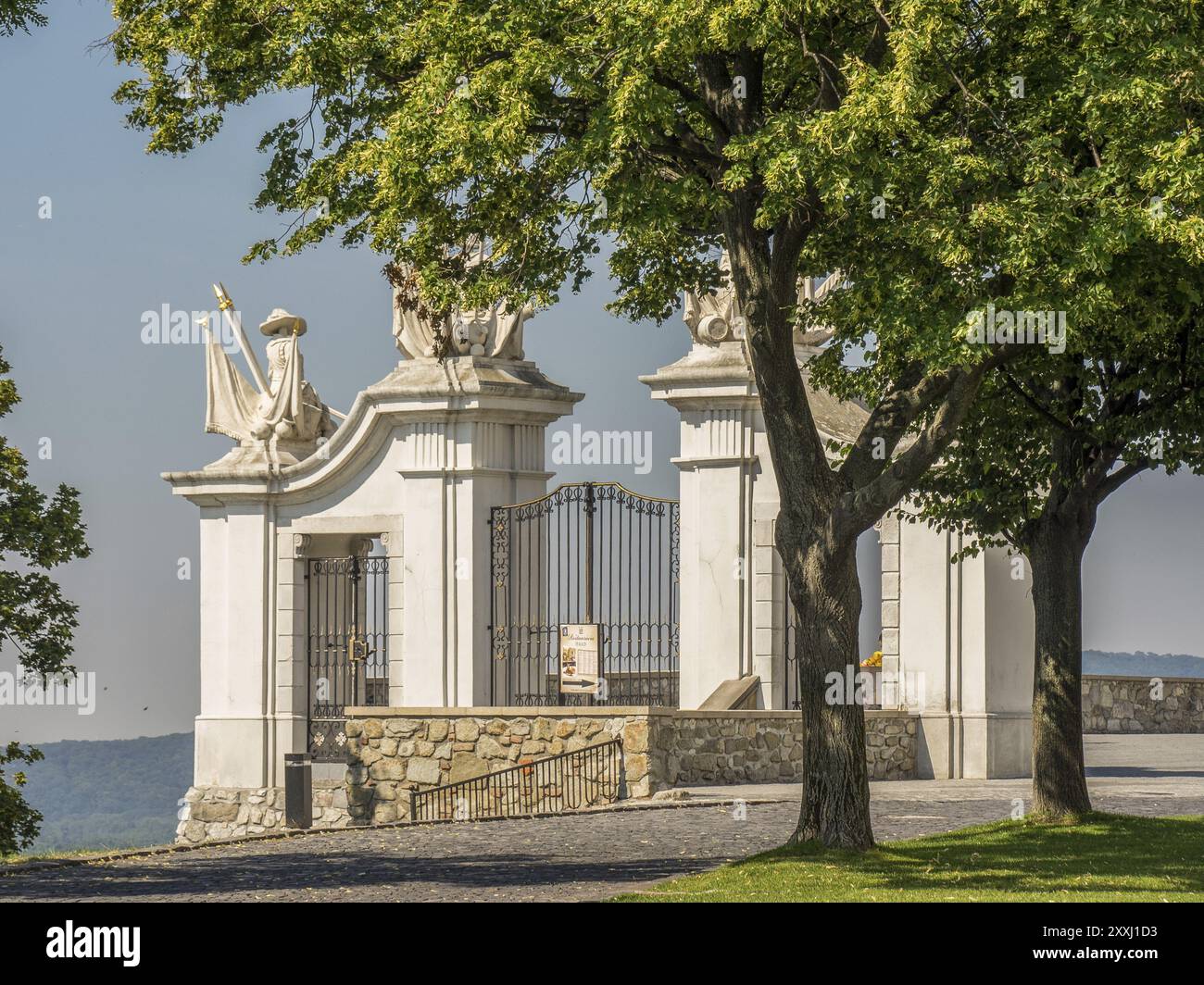 Historic Tor tor with statues next to green trees under a blue sky ...