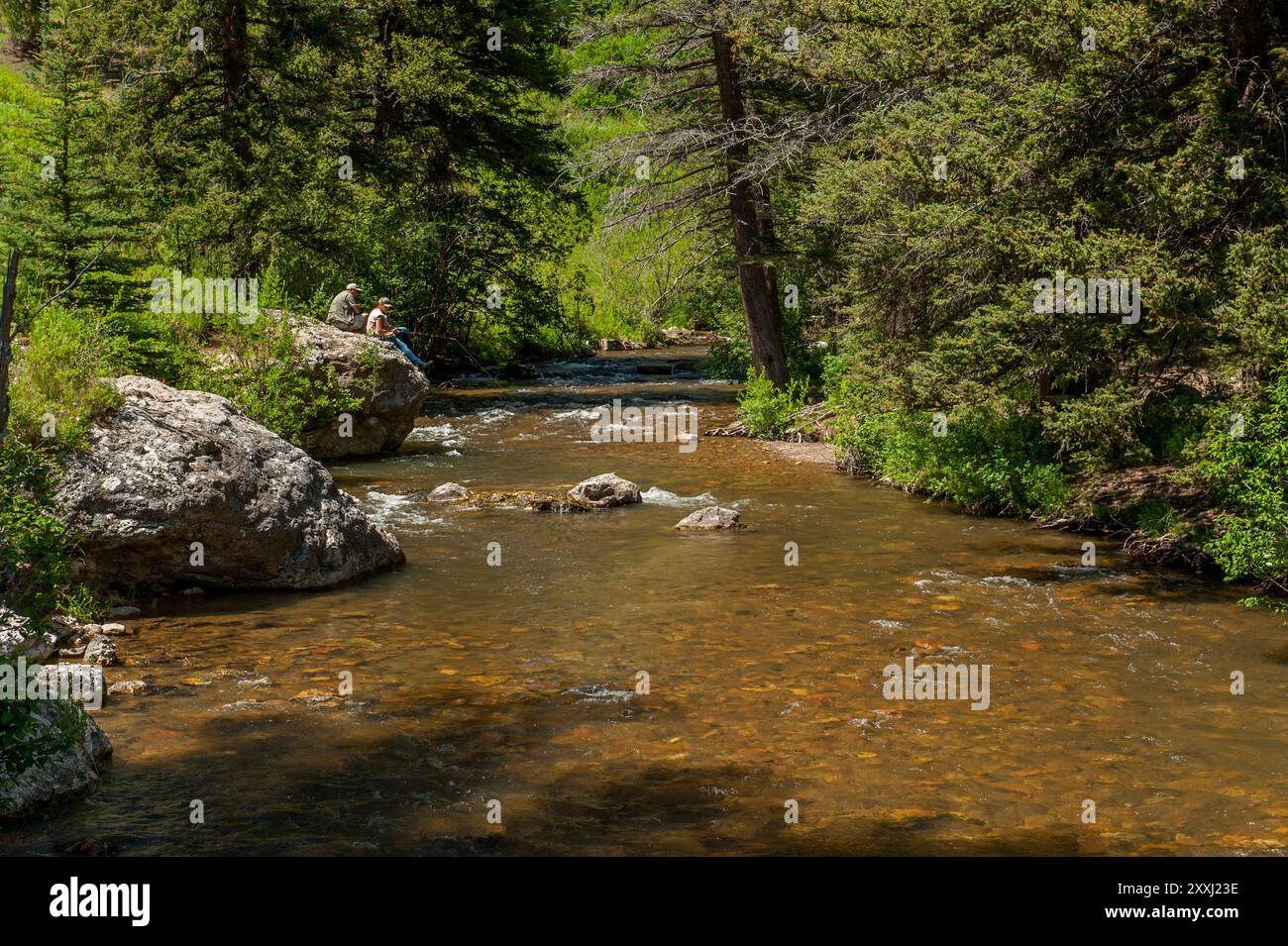 Two people fishing the Pecos River in the Sangre de Cristo mountains at ...