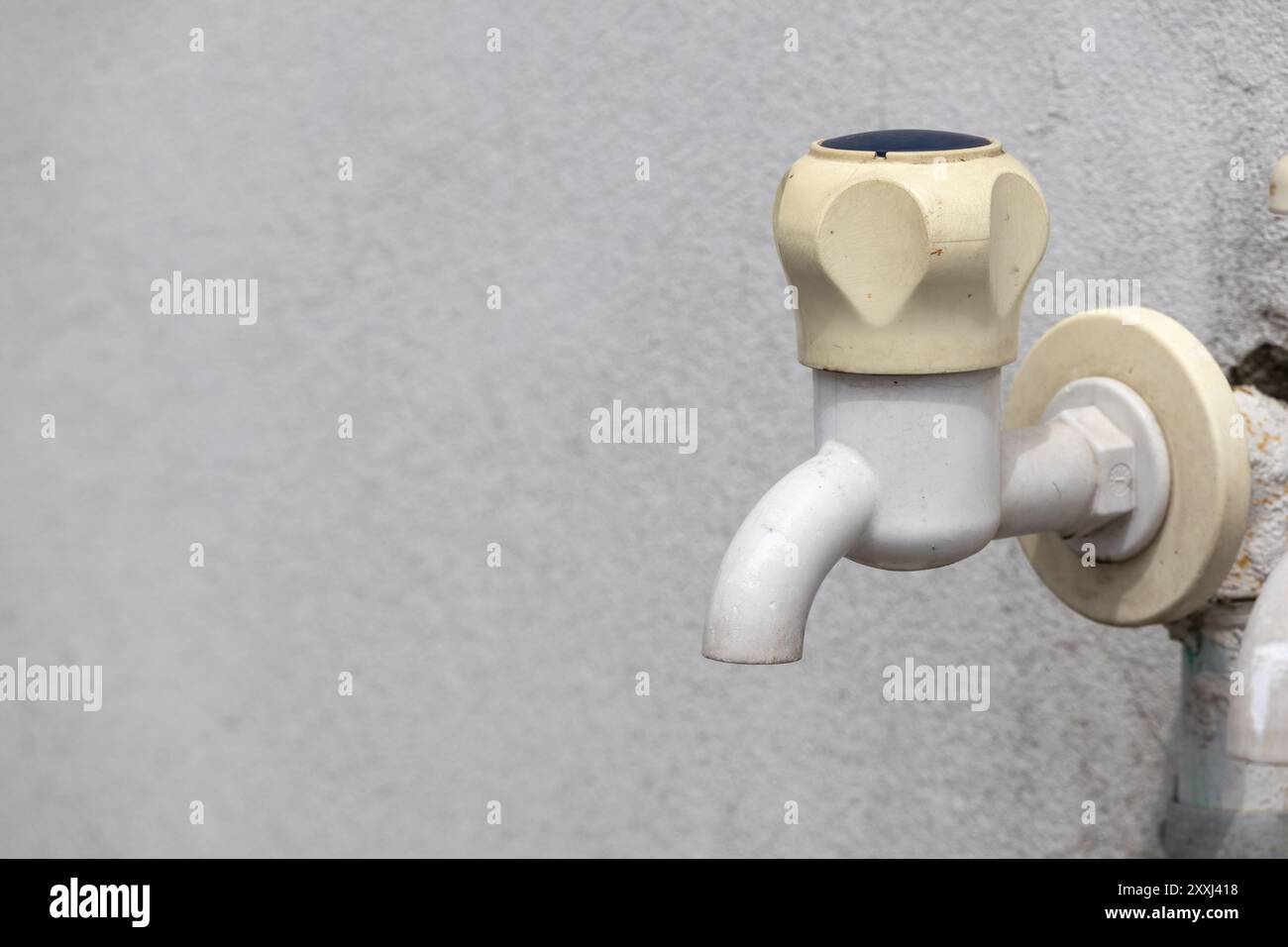 White plastic water faucet on outdoor wall Stock Photo - Alamy