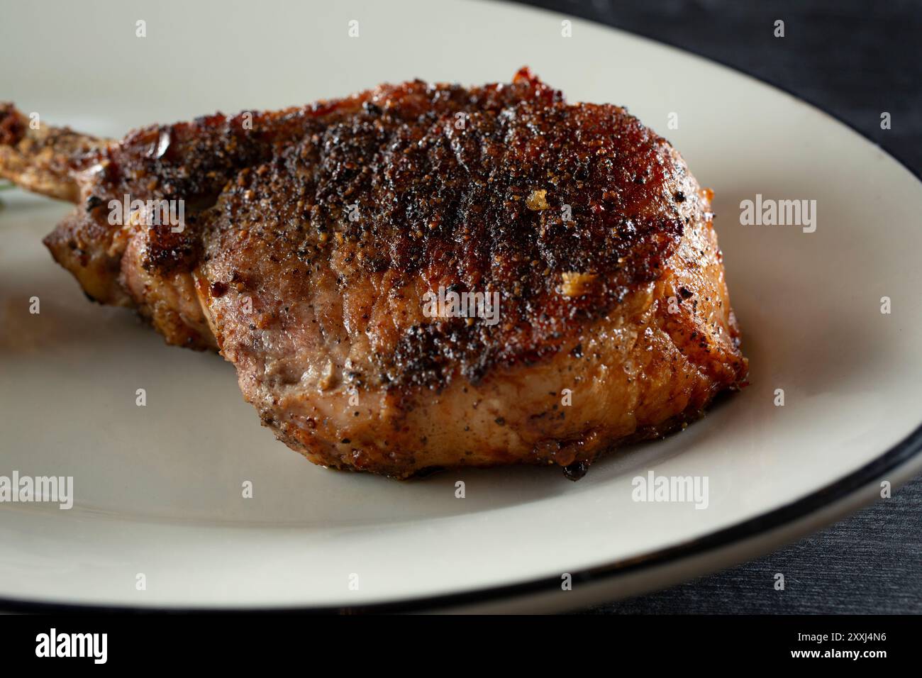 A closeup view of a bone-in Duroc pork chop on a plate Stock Photo - Alamy