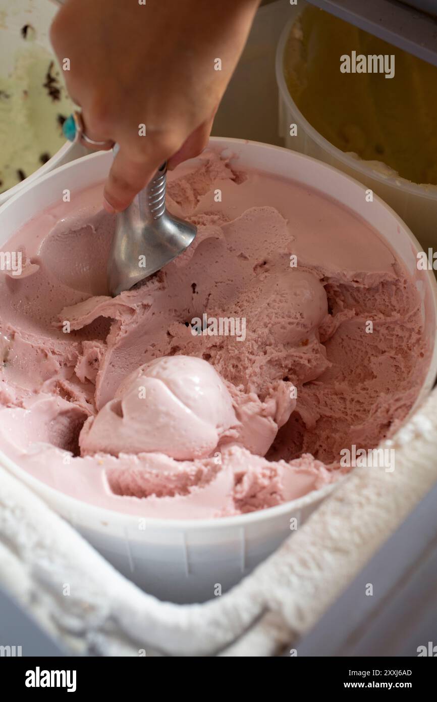 A view of a hand scooping strawberry ice cream Stock Photo - Alamy