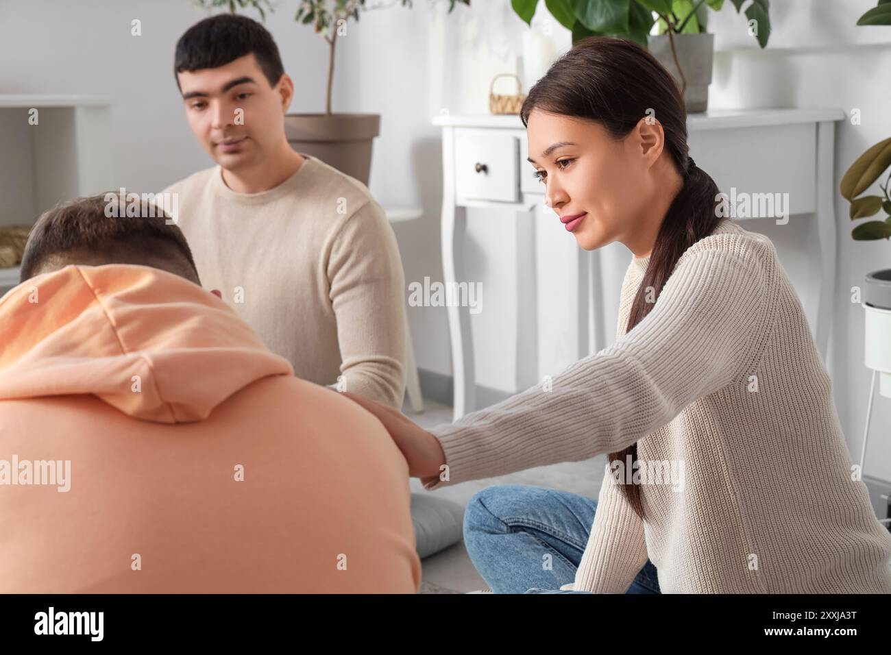 Young Asian woman calming upset man at group therapy session Stock ...