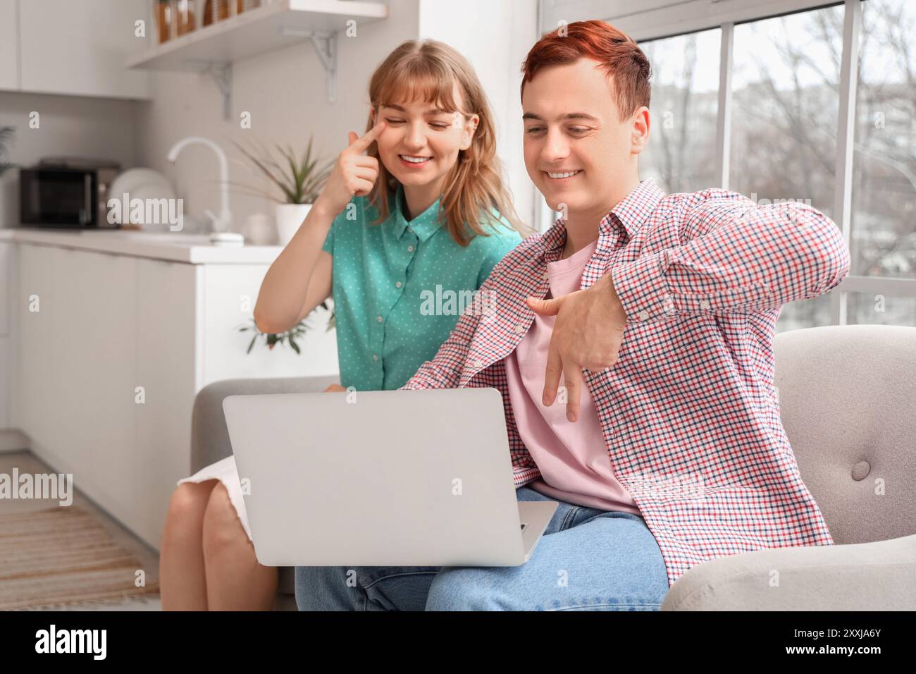 Young deaf mute couple video chatting in sign language at home Stock ...