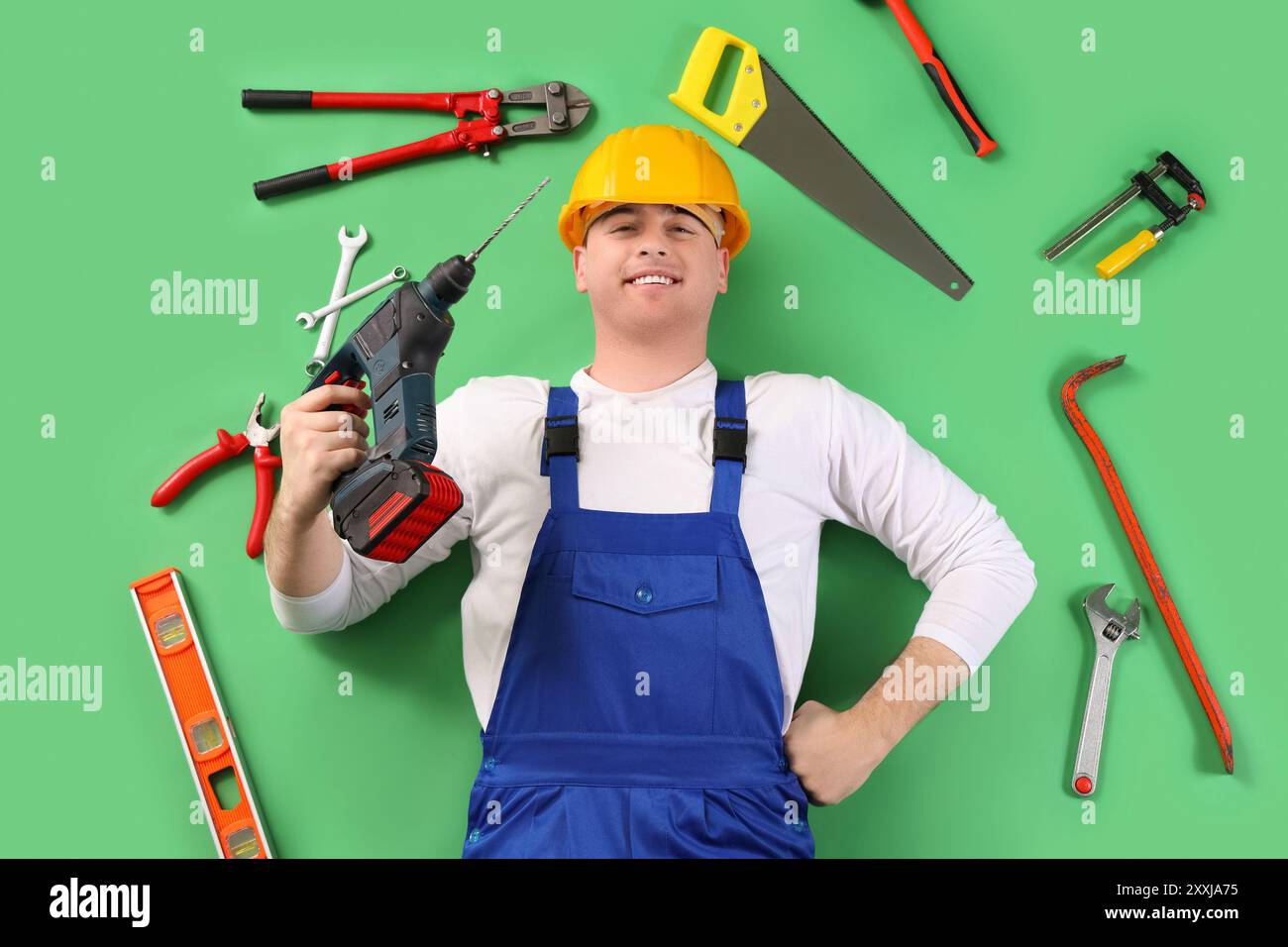 Male builder with work tools on green background, top view Stock Photo ...