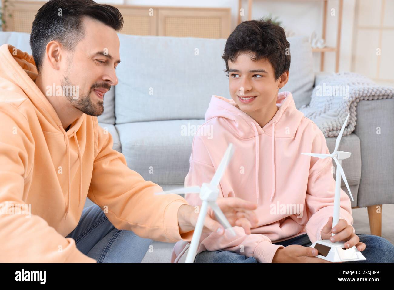 Teenage boy and his father with wind turbine models at home Stock Photo ...