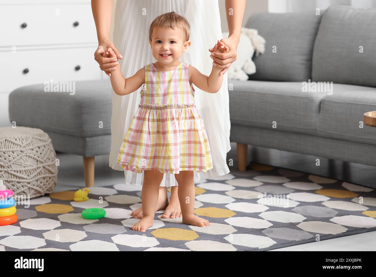 Little baby girl learning to walk with mother at home Stock Photo - Alamy