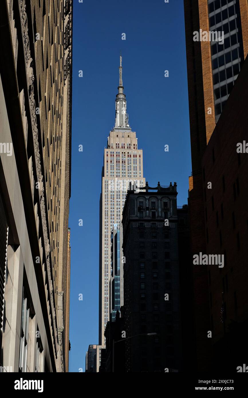 Looking up at the Empire State Building rising out of the canyon of ...