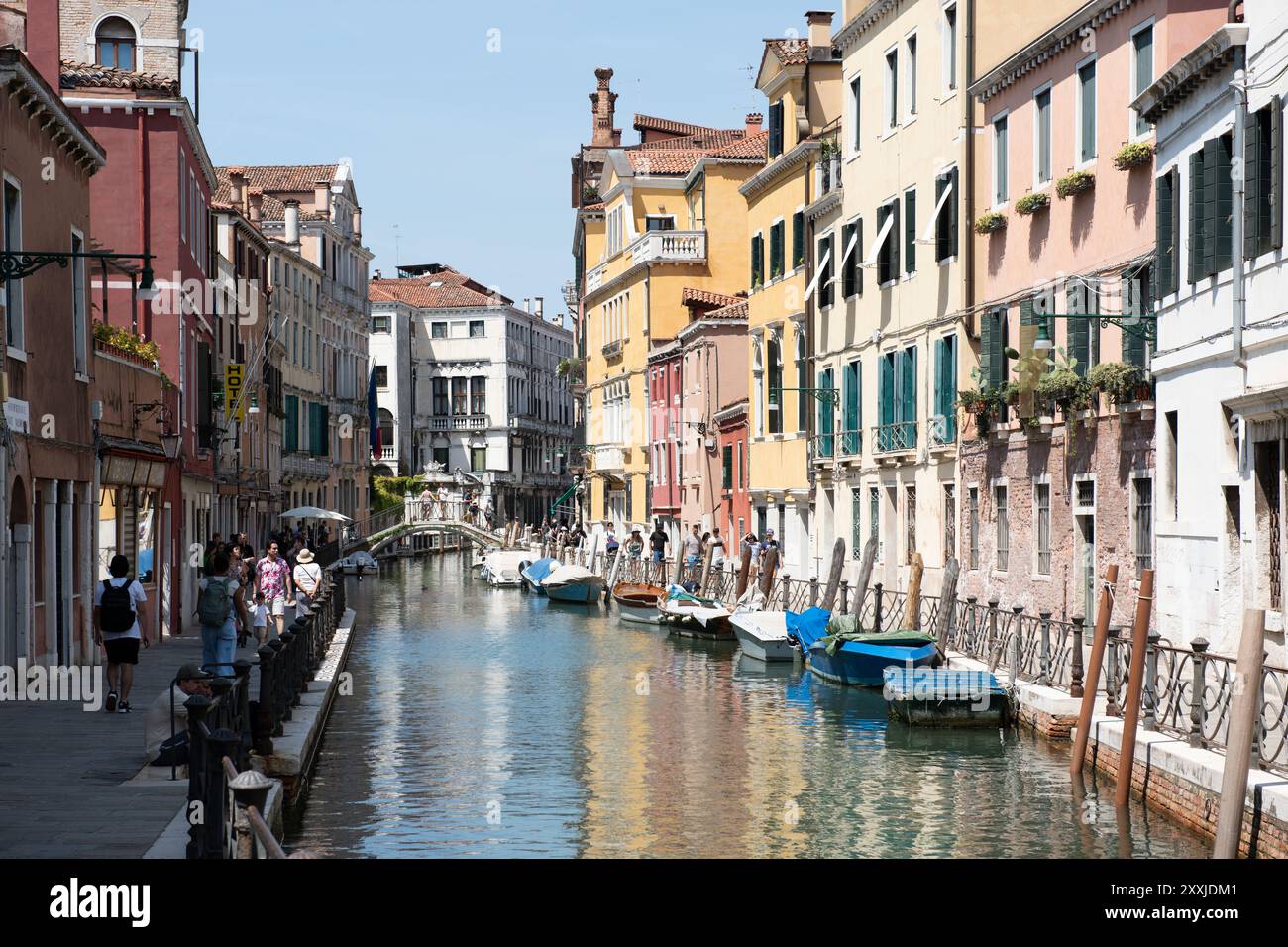 Typical Venetian street scene with canal, boats and ancient buildings ...