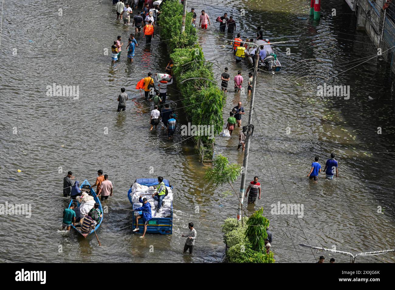 Dhaka, Bangladesh. 24th Aug, 2024. People wade through floodwater in ...
