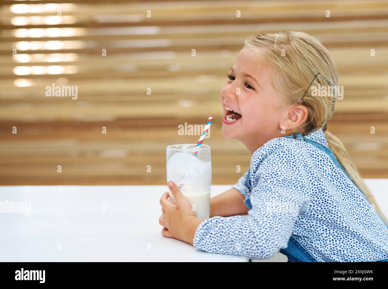 Girl, child and milk in home, laughing and nutrition liquid for growth ...