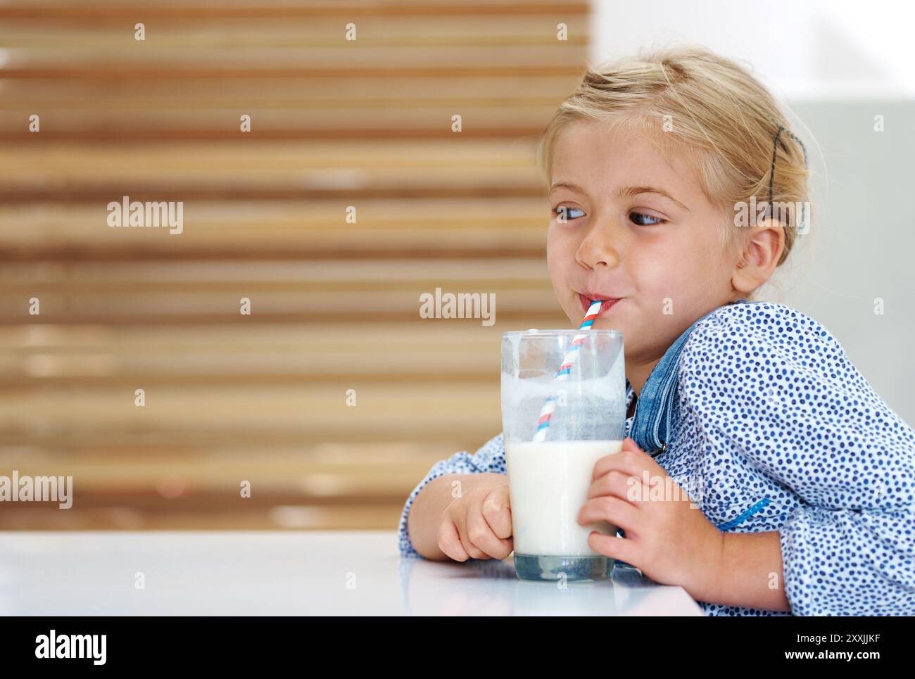 Girl, child and drinking milk in home, nutrition and vitamin d liquid ...