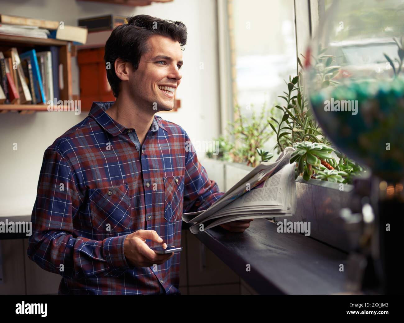 Man, phone and newspaper for thinking at coffee shop, texting and app ...