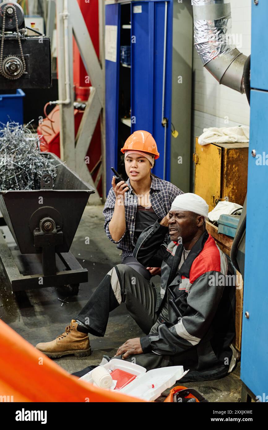 Workers engaged in communication on a busy industrial worksite with ...