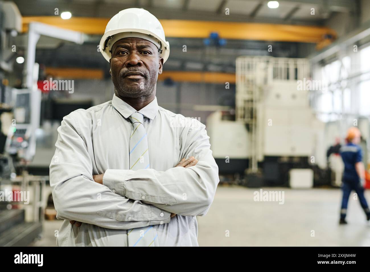 Portrait of African American engineer wearing white hardhat standing in ...
