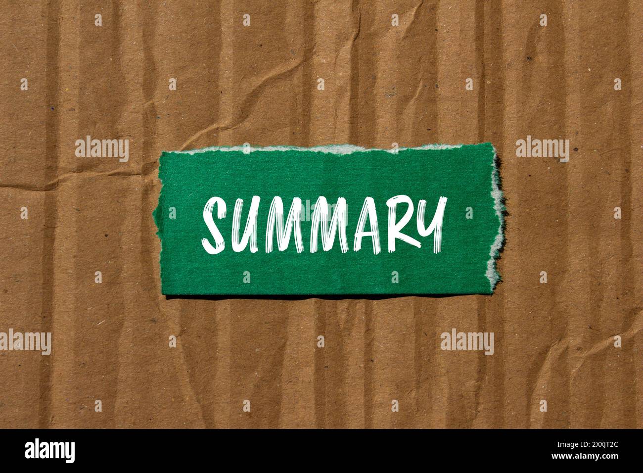 Summary word written on ripped torn green paper piece with cardboard background. Conceptual ...
