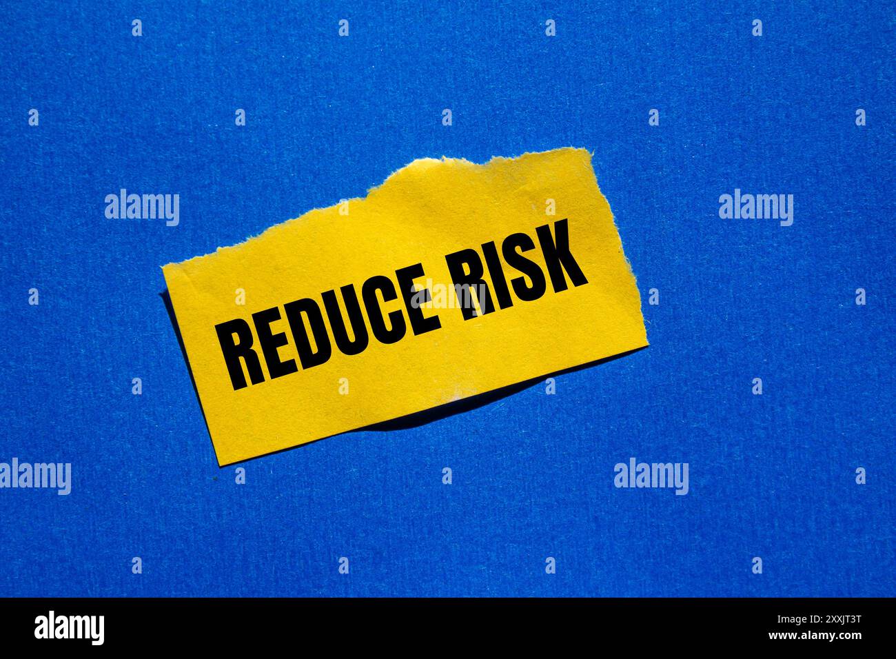 Reduce risk message written on ripped torn yellow paper piece with ...