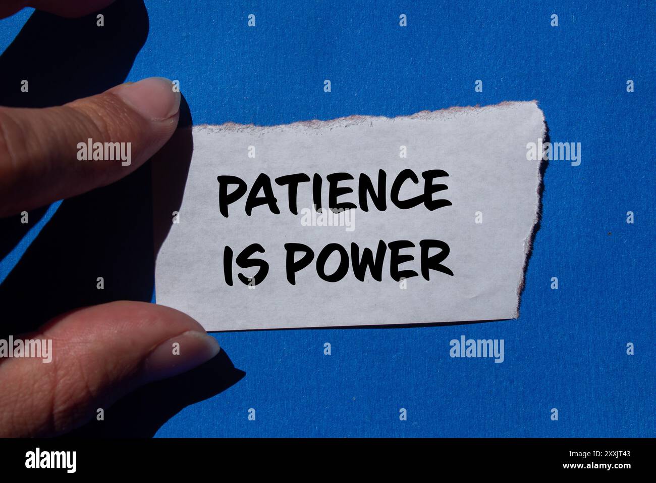 Patience is power message written on ripped torn paper with blue ...