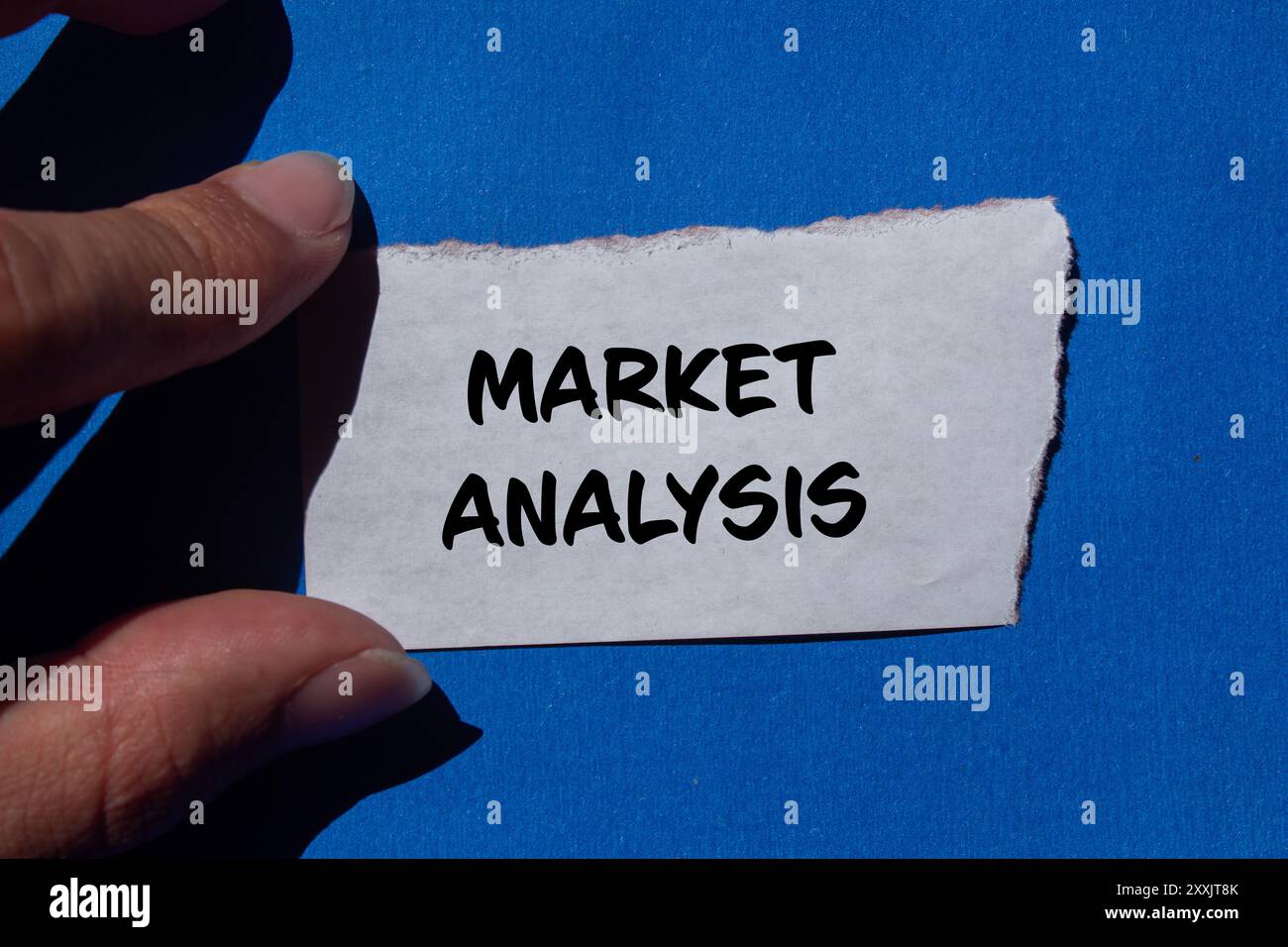 Market analysis message written on ripped torn paper with blue ...