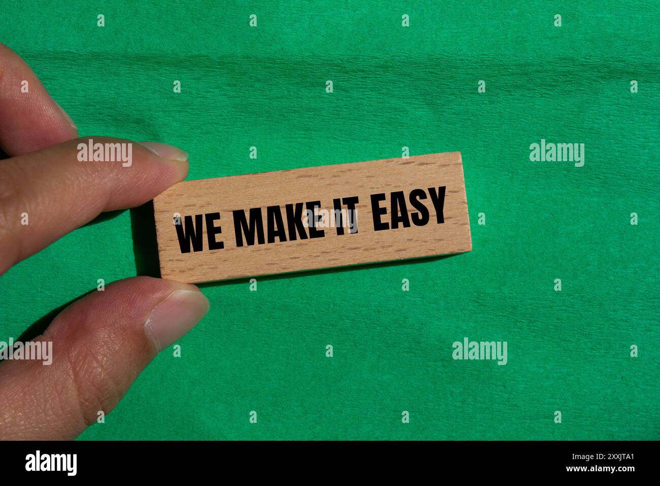 We make it easy message written on wooden block with green background ...