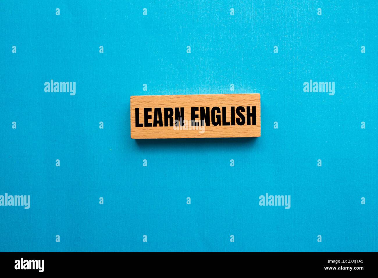 Learn english message written on wooden block with blue background ...