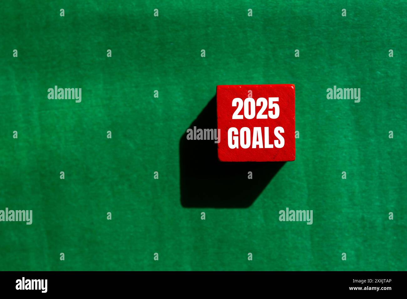 2025 goals message written on red wooden cube with green background ...