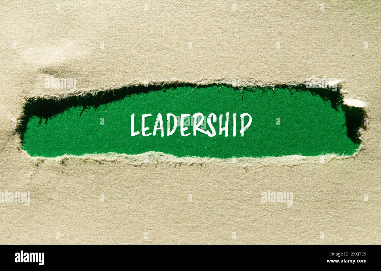 Leadership message written on ripped torn paper with green background. Conceptual leadership ...