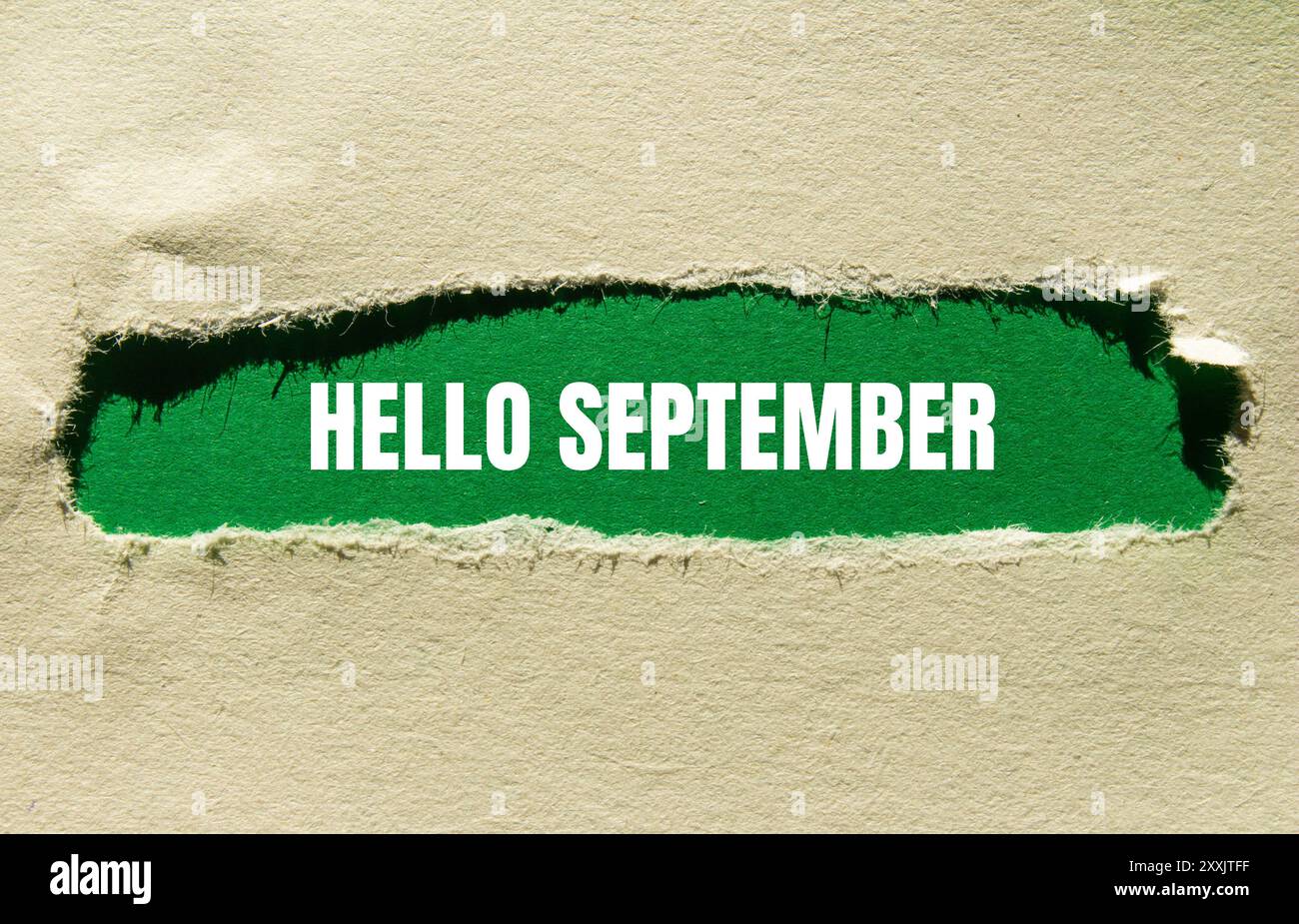 Hello september message written on ripped torn paper with green ...