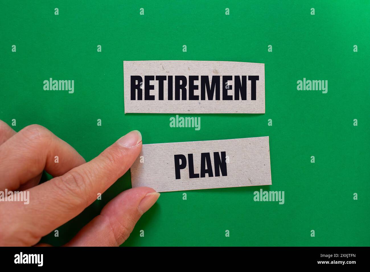 Retirement plan message written on paper pieces with green background ...
