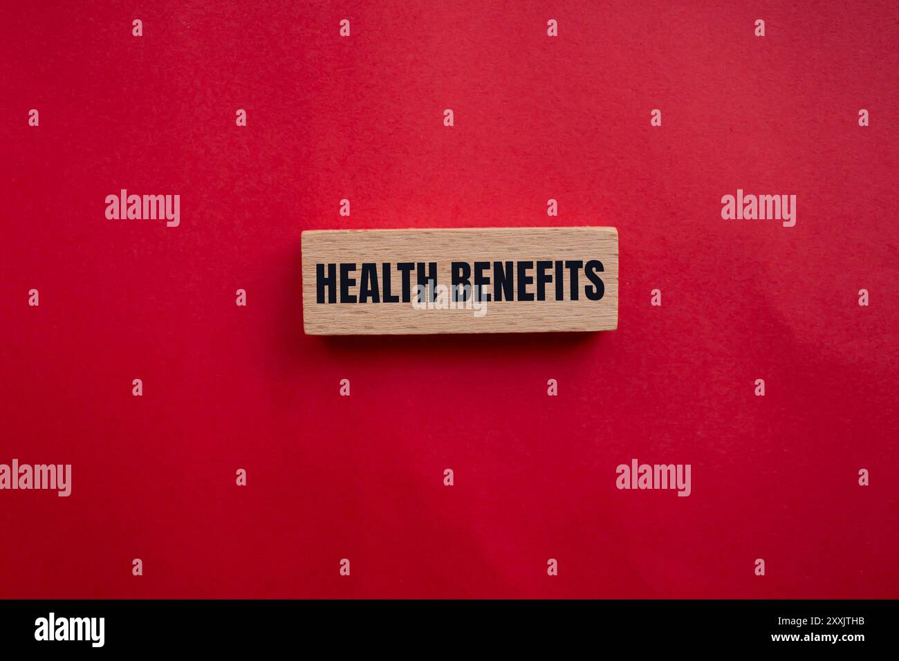 Health benefits message written on wooden block with redbackground ...