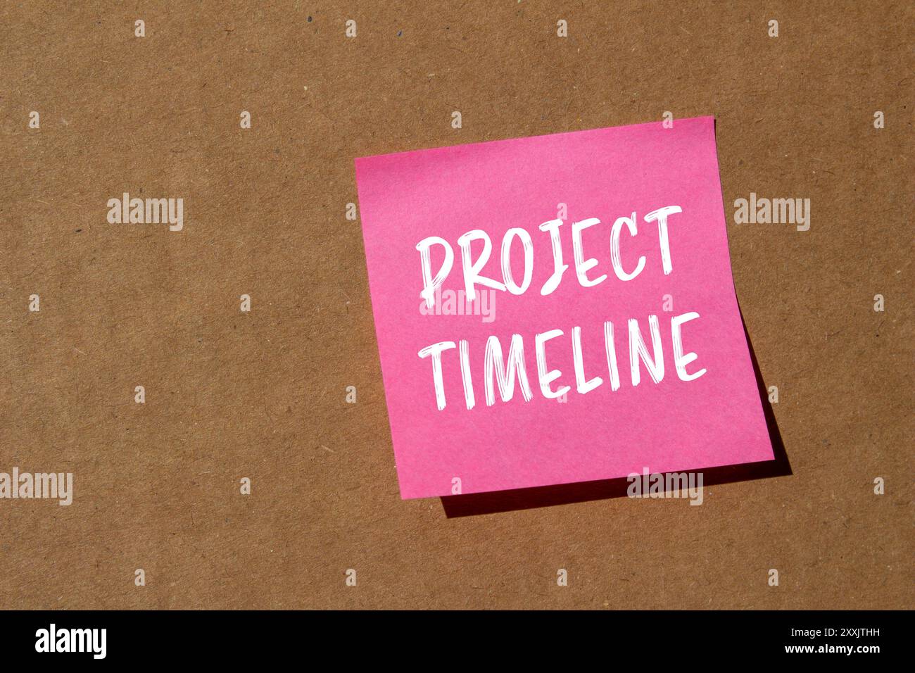 Project timeline message written on pink paper with cardboard ...