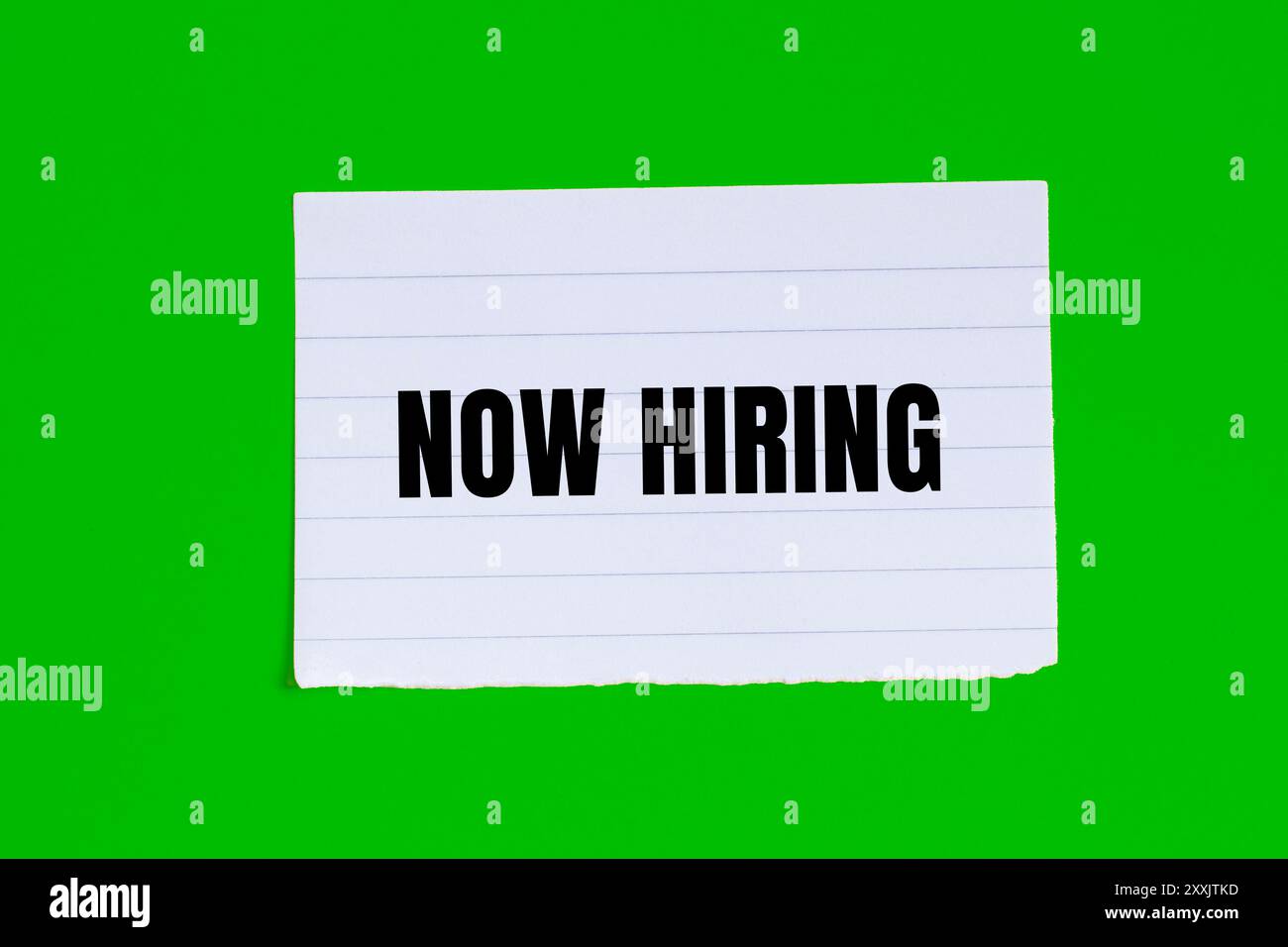 Now hiring message written on ripped torn paper piece with green ...