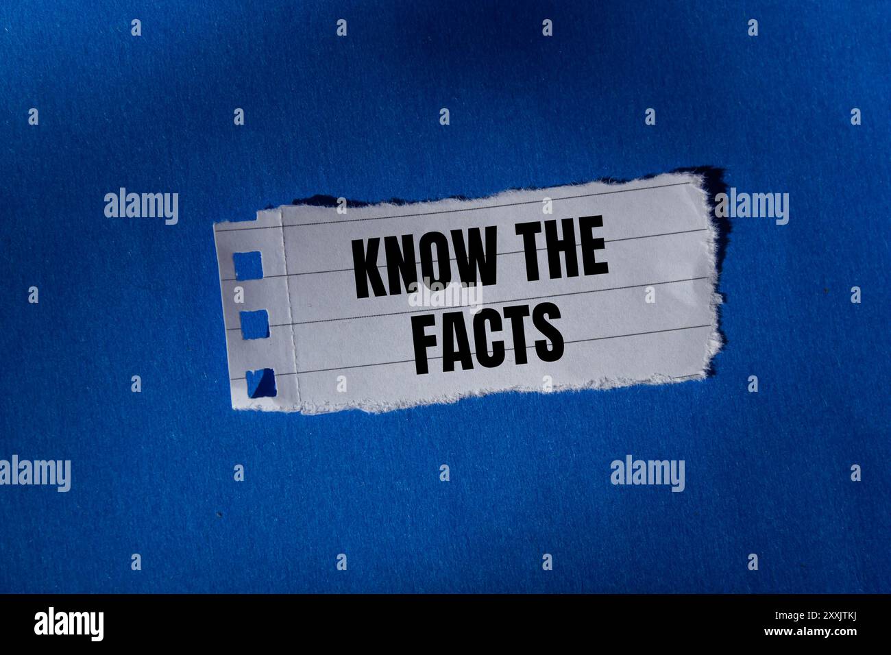 Know the facts message written on ripped torn paper piece with blue ...