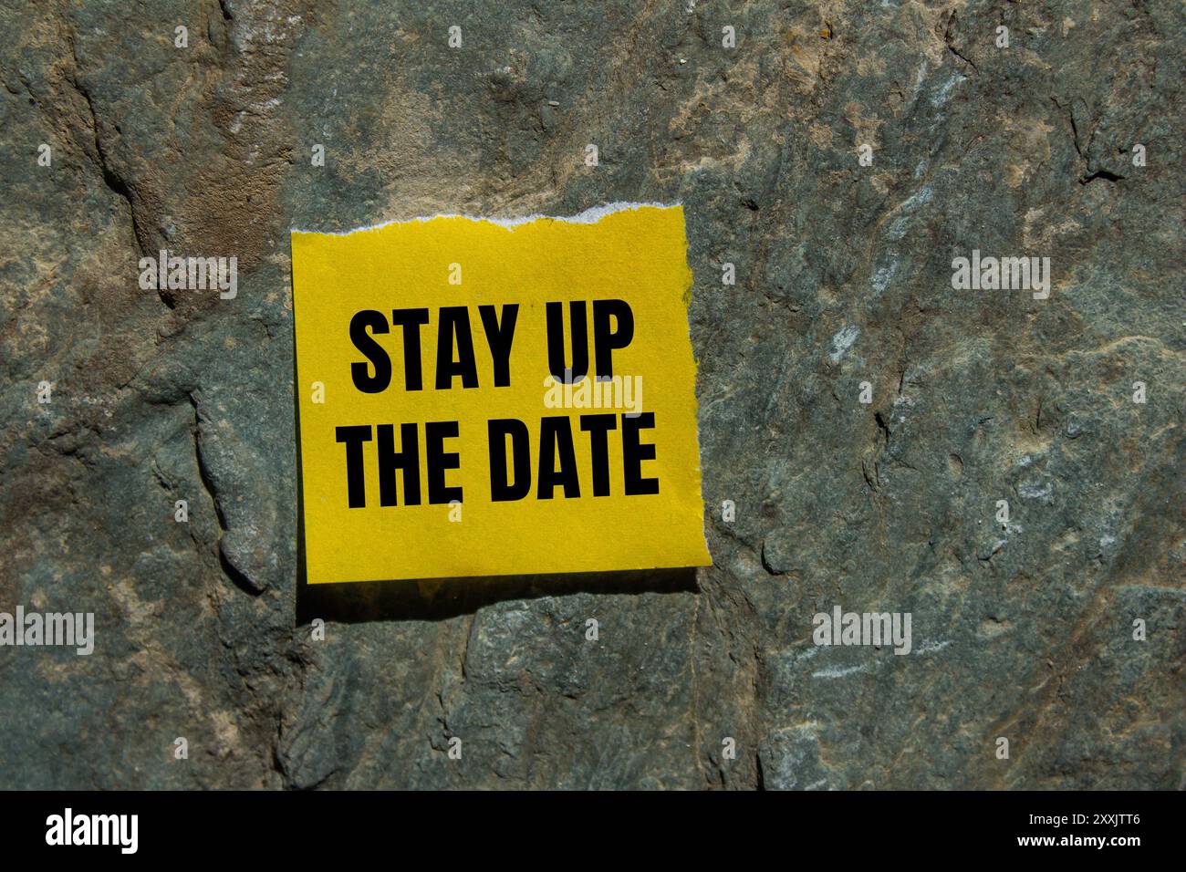 Stay up the date message written on ripped yellow torn paper piece with ...