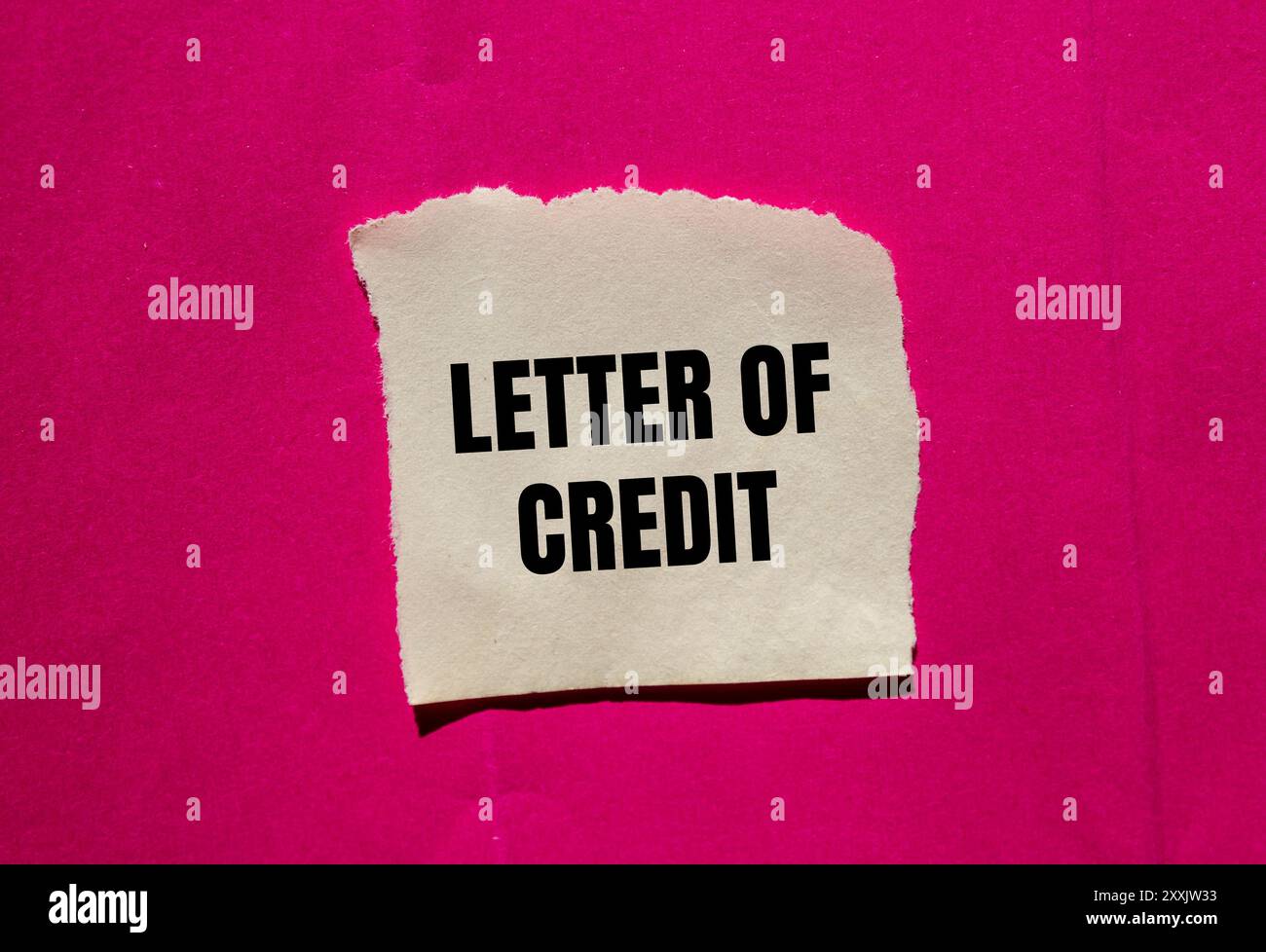 Letter of credit message written on ripped torn paper piece on pink ...