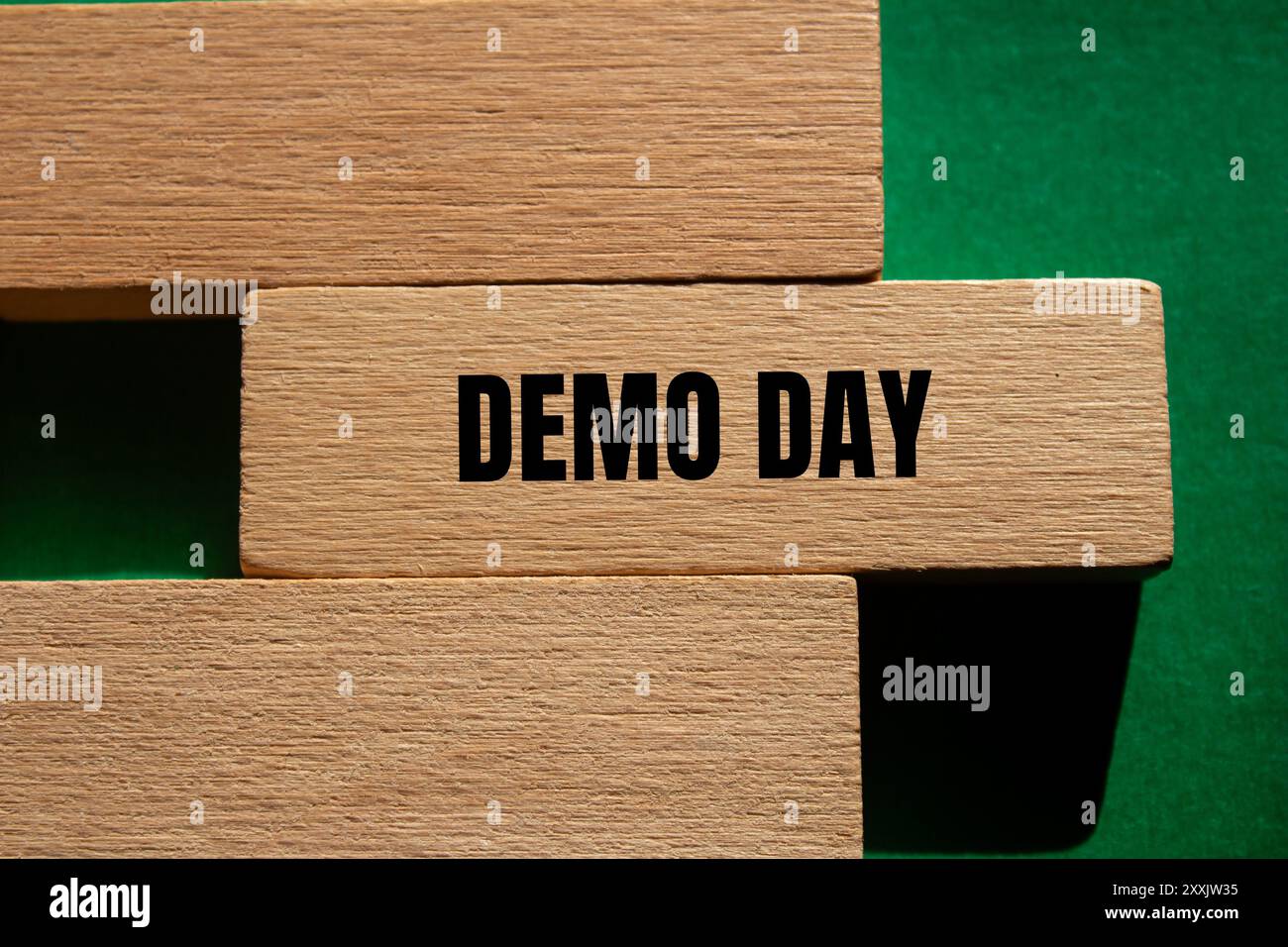 Demo day message written on wooden block with green background ...