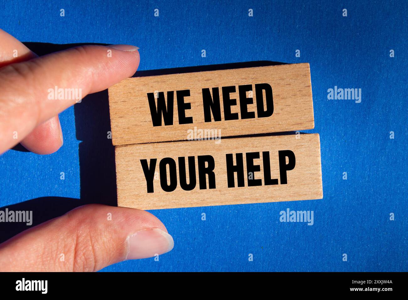 We need your help message written on wooden blocks on blue background ...