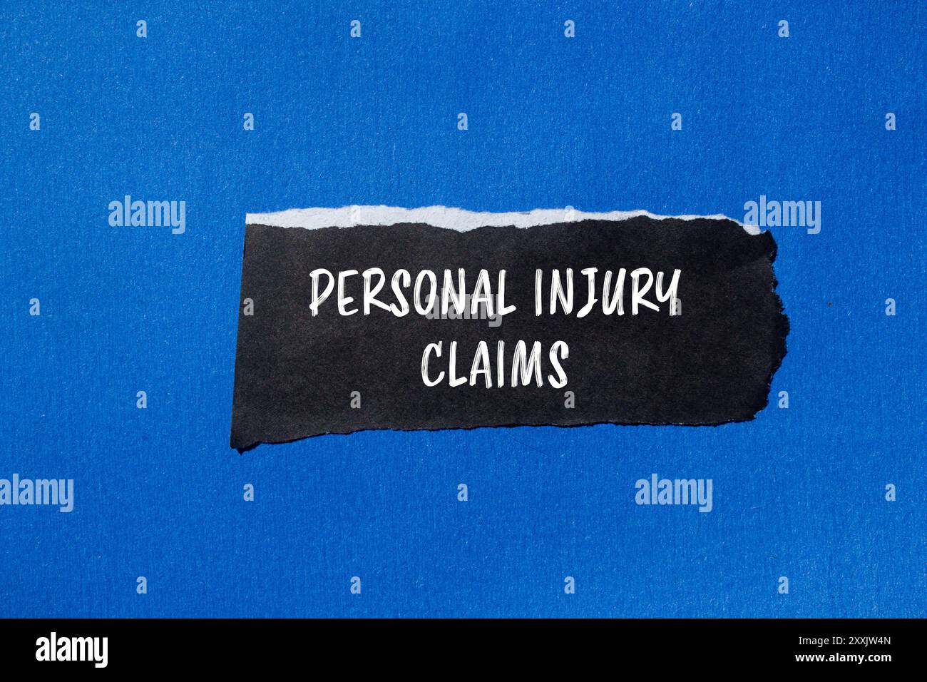Personal injury claims message written on ripped torn black paper piece ...