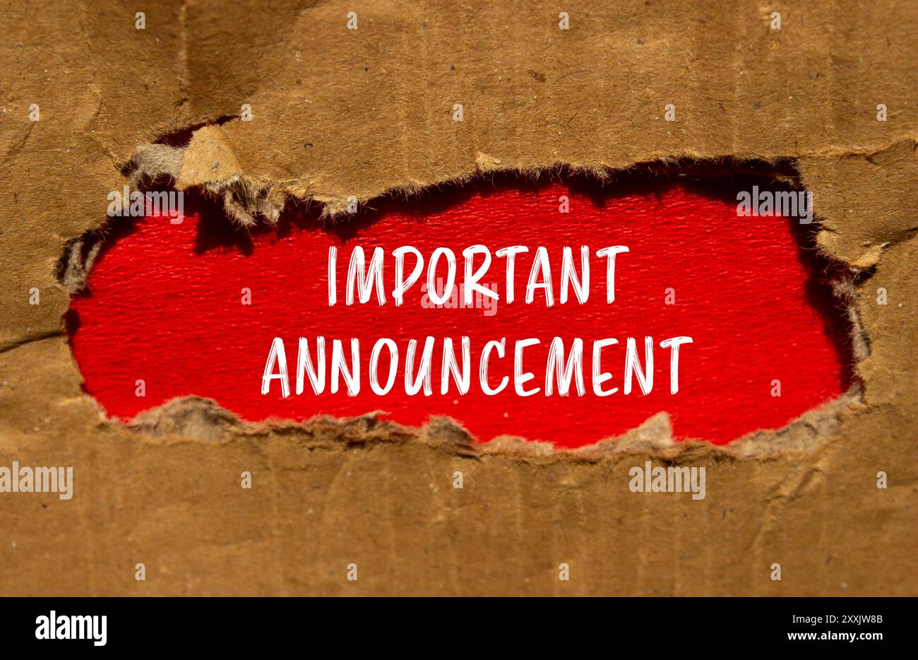 Important announcement message written on torn cardboard paper with red ...