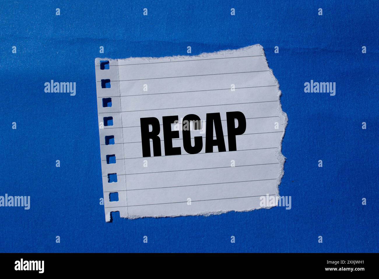 Recap message written on ripped torn paper piece with blue background. Conceptual recap symbol ...
