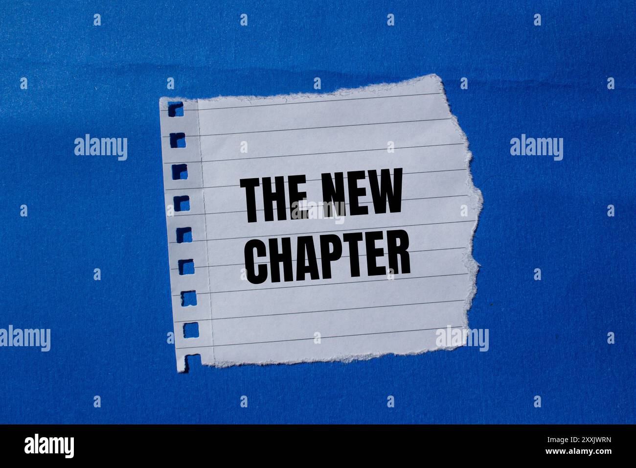 The new chapter message written on ripped torn paper piece with blue ...