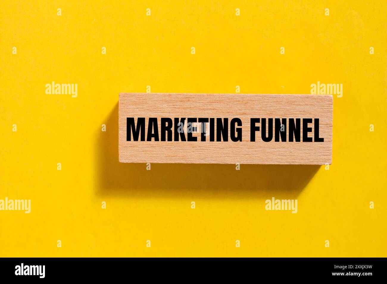 Marketing funnel message written on single wooden block with yellow ...